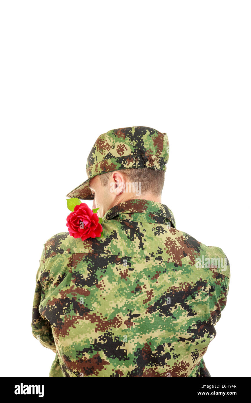 Soldier with turned back holding red rose over shoulder with romantic ...