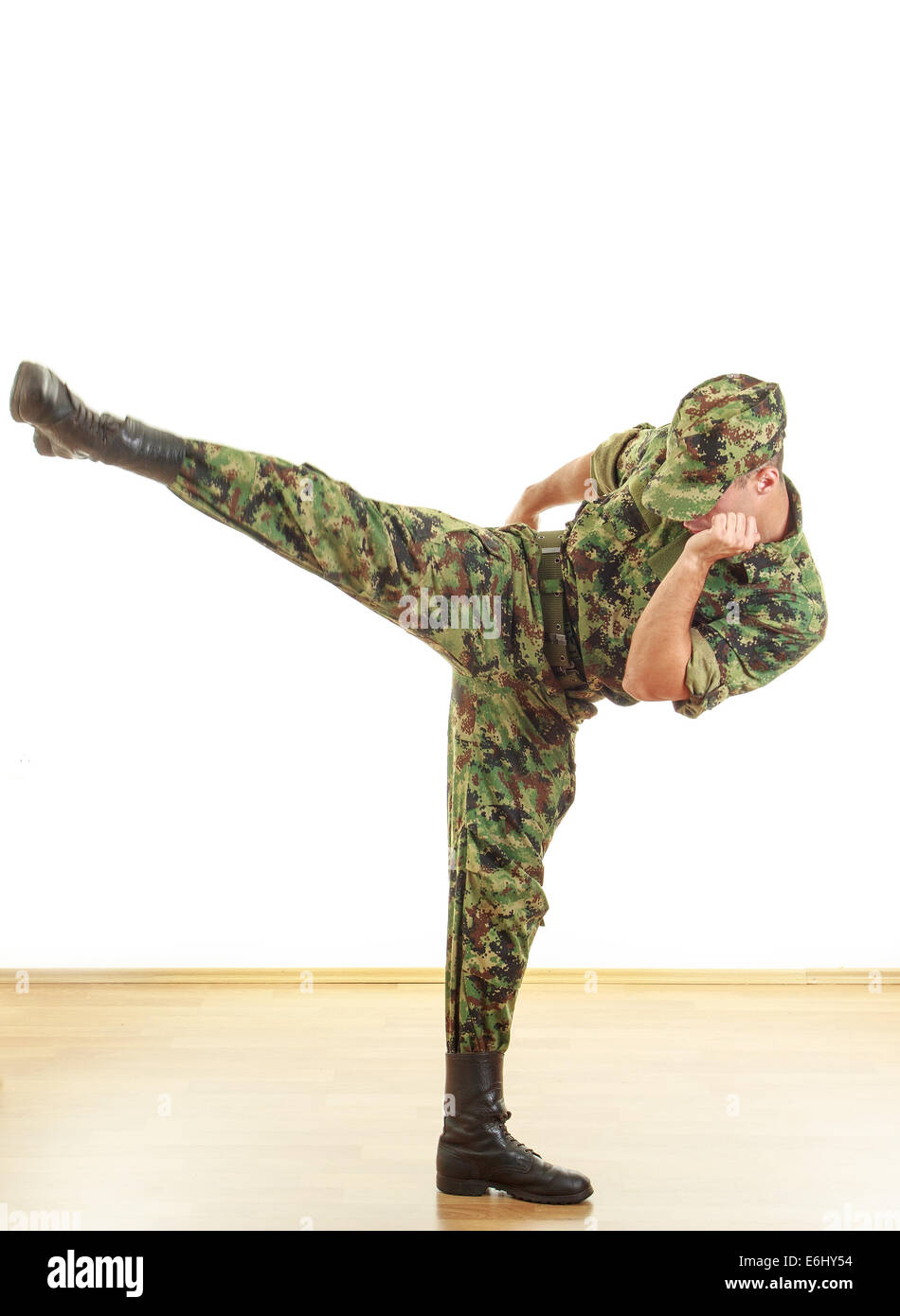 unknown soldier with hidden face in green camouflage uniform kicking on ...