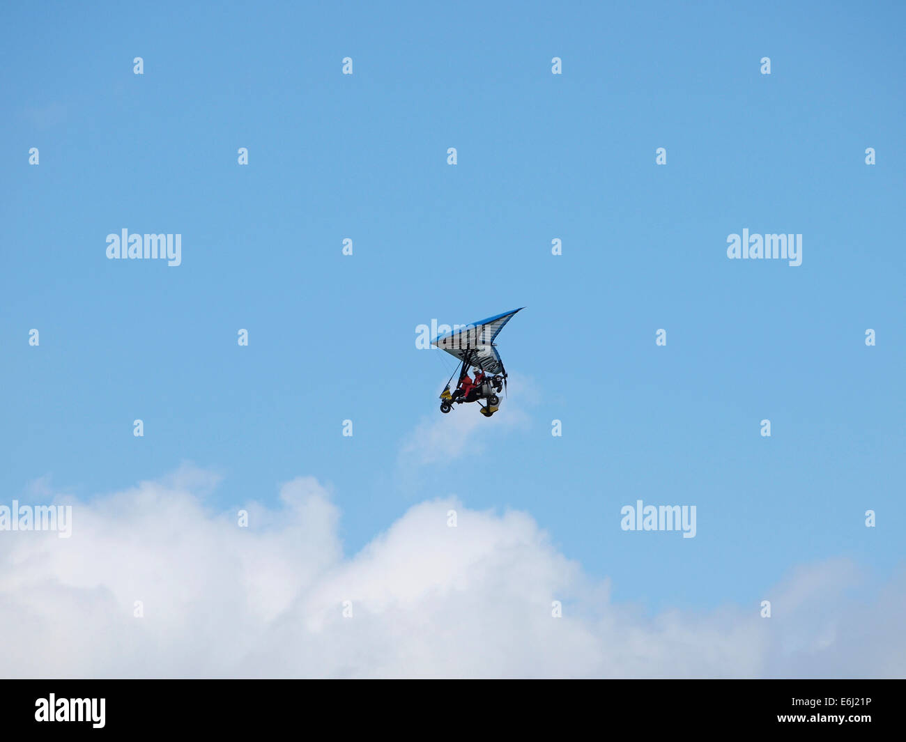 Ultralight aeroplane in blue sky with clouds, passenger waving, Jura ...