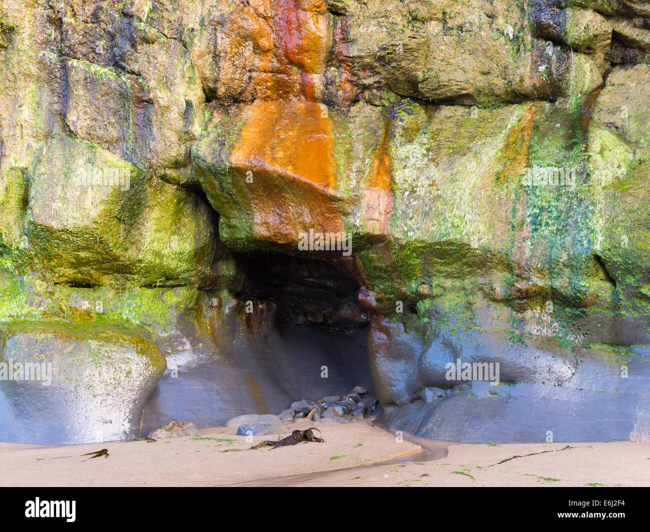 Wave worn cliffs in former iron mining area with a small mined adit ...