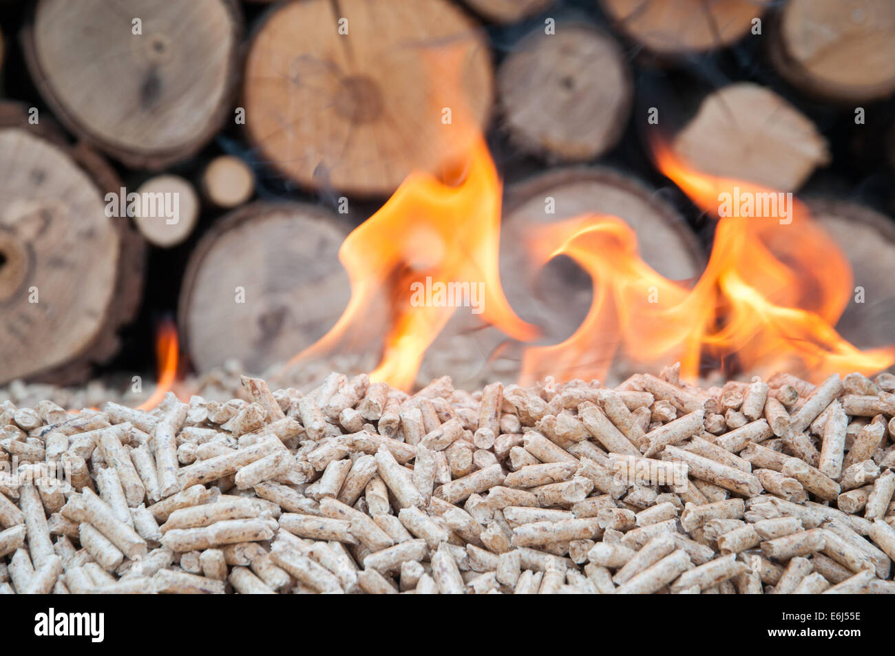 Pine pellets in front a wall of firewoods in flames Stock Photo - Alamy