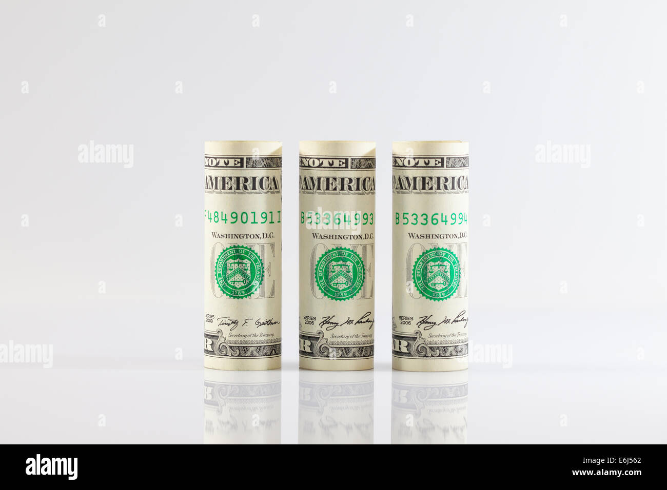 Rolls of dollar bills on a glass table Stock Photo - Alamy