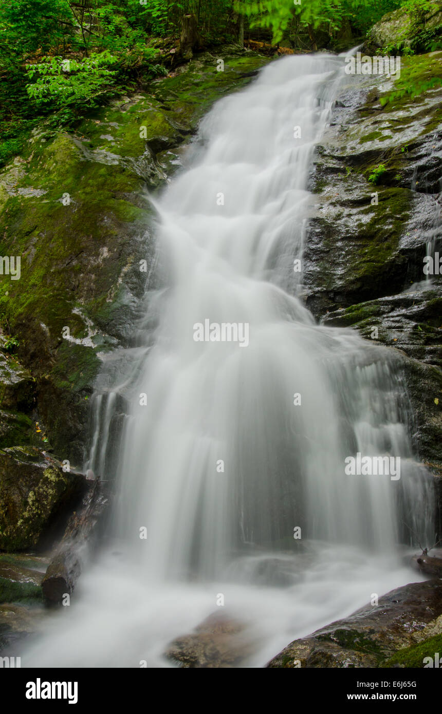 A slow shutter speed captures water cascading off of a rock face along ...