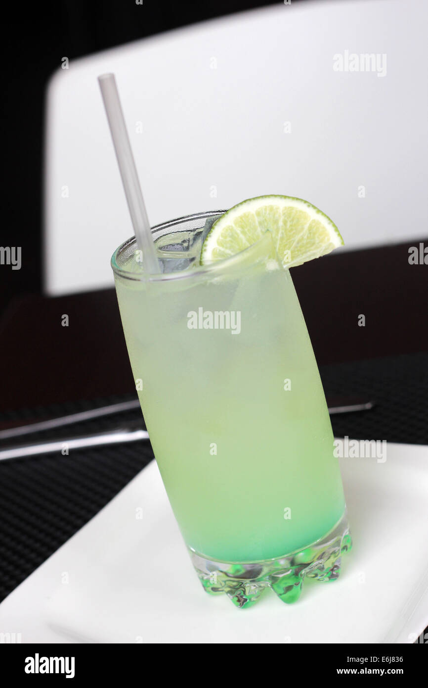 Glass with an icy lemonade drink served with a small slice of lemon ...