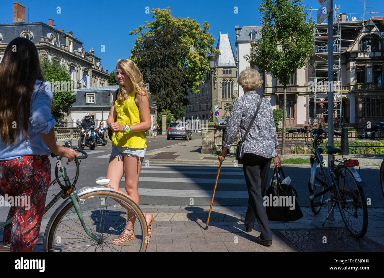 2 young girls chatting and elderly woman walking with cane, street ...