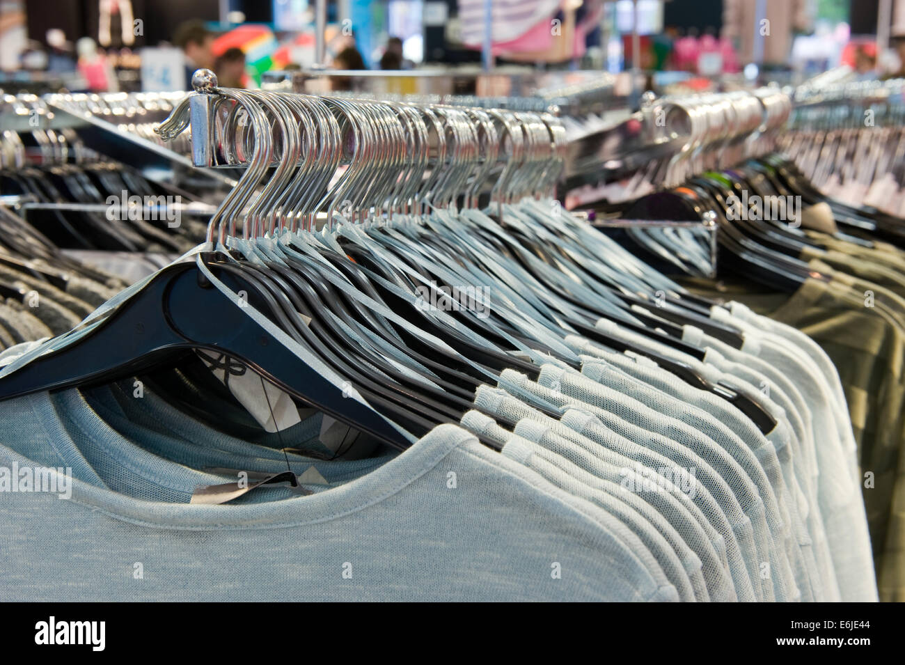 Clothes hangers with clothes in a shop Stock Photo - Alamy