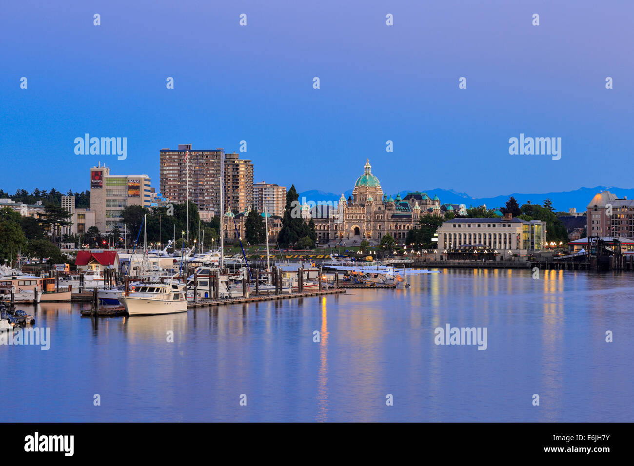 Inner harbor and Legislative buildings and city skyline at dusk ...