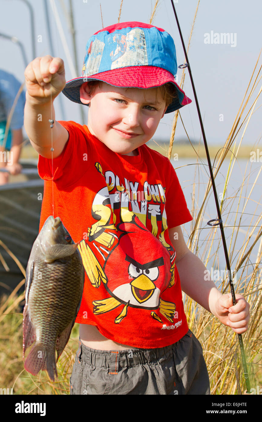 Young boy holding bream fish he caught on the Lower Zambezi River Stock ...