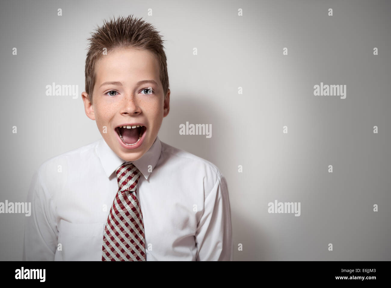 The cute smiling screaming boy teenager in a white shirt and a tie on a ...