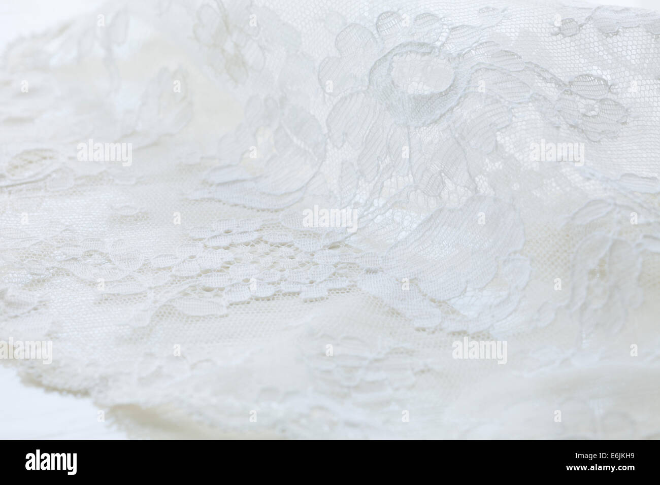 A small, delicate piece of machine-made lace, photographed life size in ...