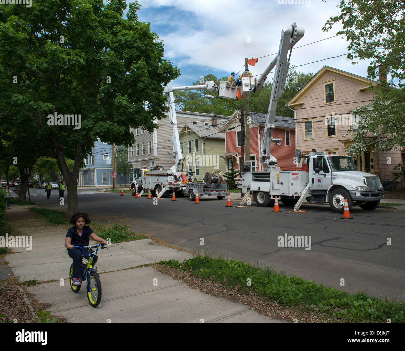 Electricians use cherry picker trucks to work on installing new power ...