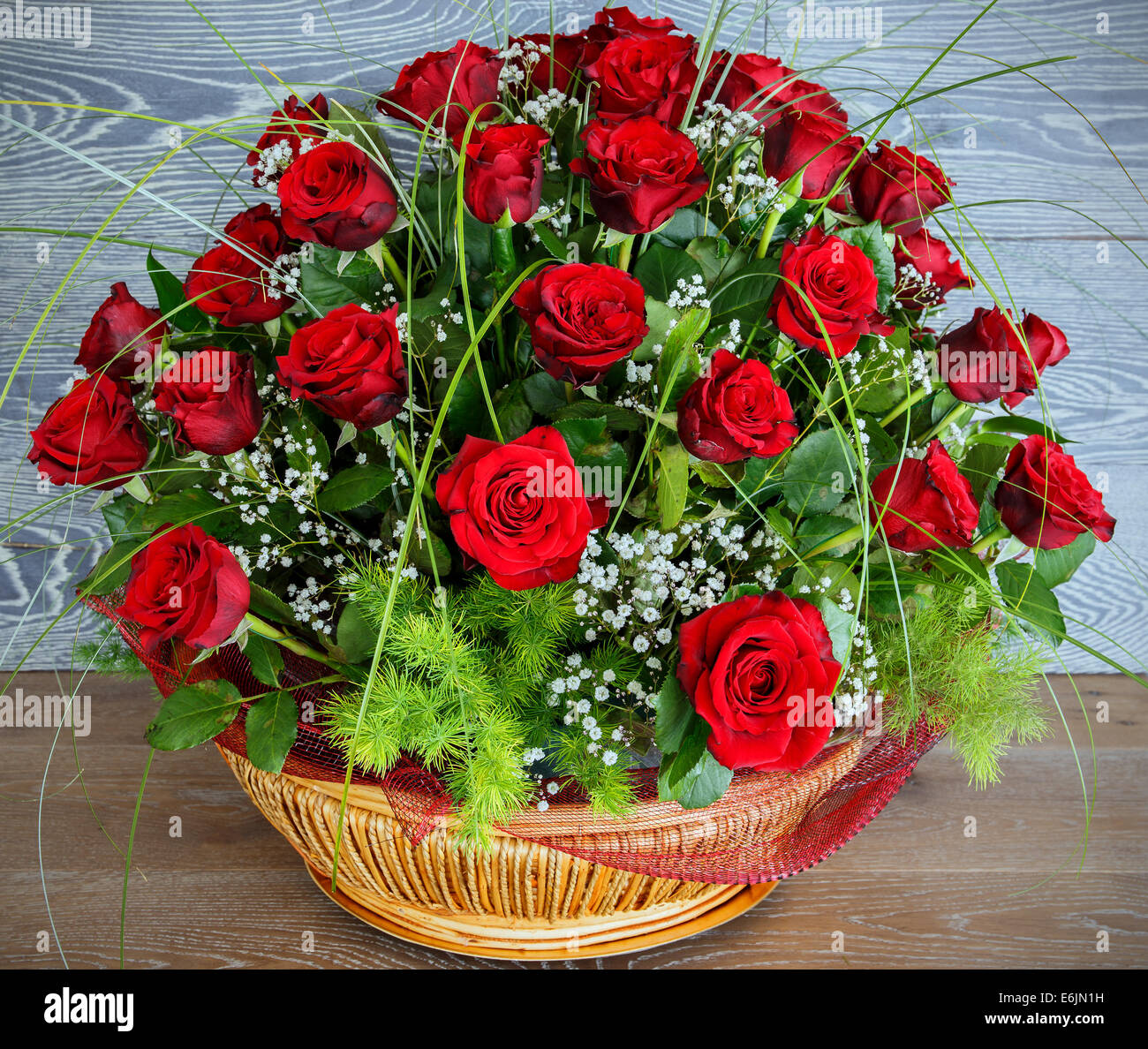 Beautiful red roses bouquet against wooden background Stock Photo - Alamy
