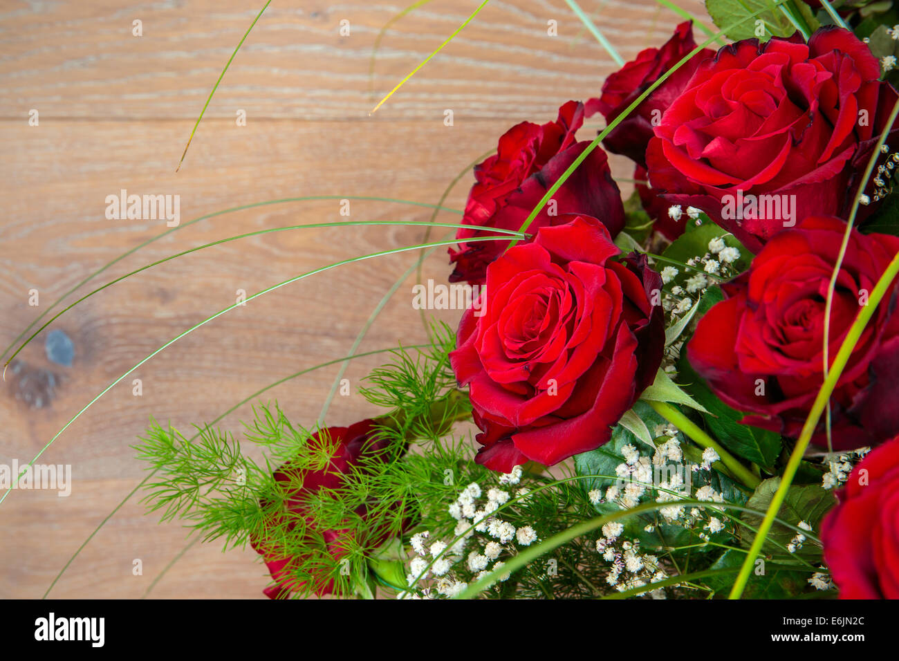 Beautiful red roses bouquet against wooden background Stock Photo - Alamy