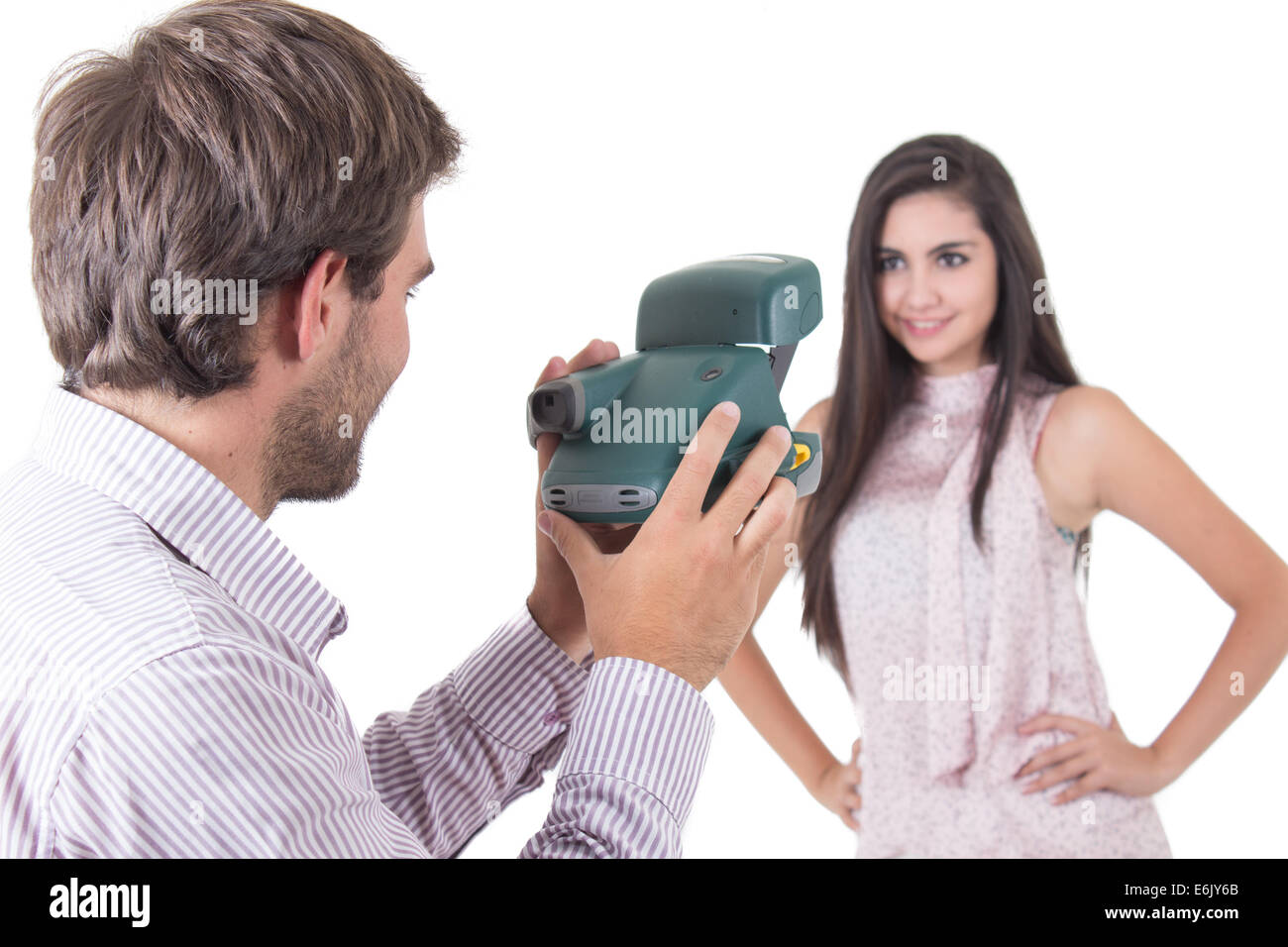 Handsome young man taking photos of beautiful girl with instant camera ...