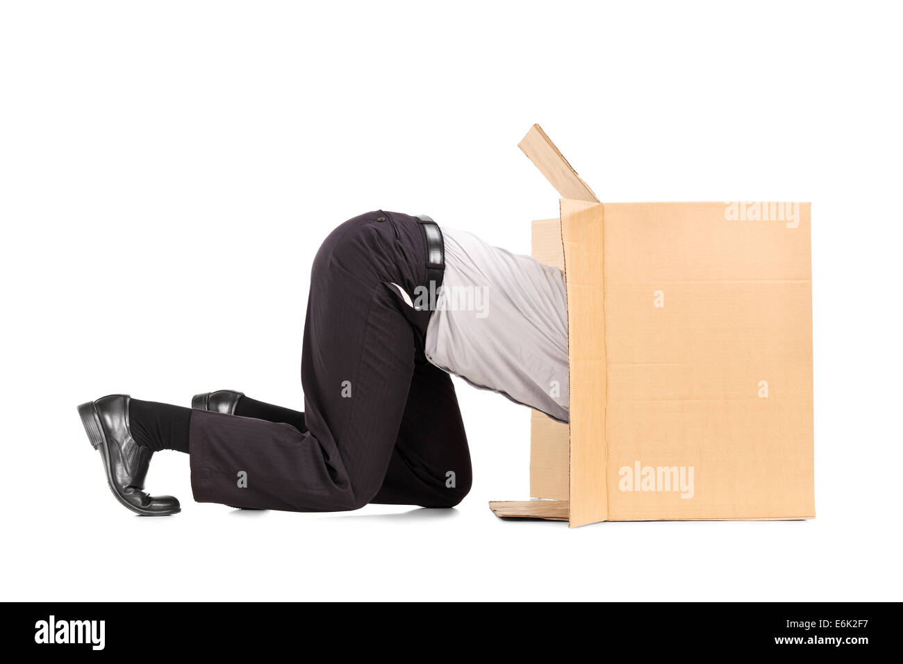 Businessman squeezing himself into a box isolated on white background ...