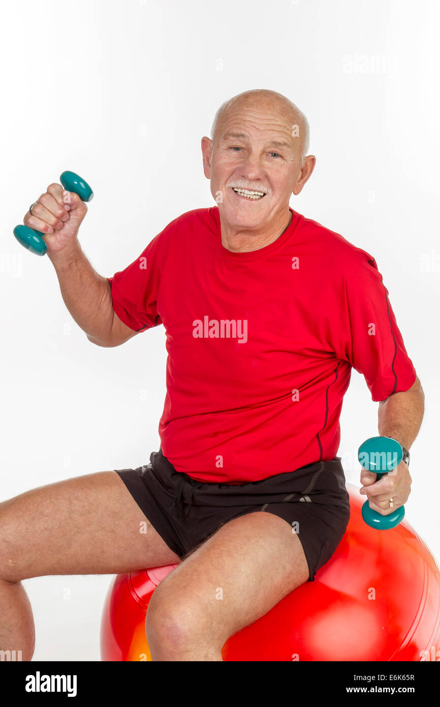 Elderly man sitting on a stability ball holding small dumbbells Stock ...