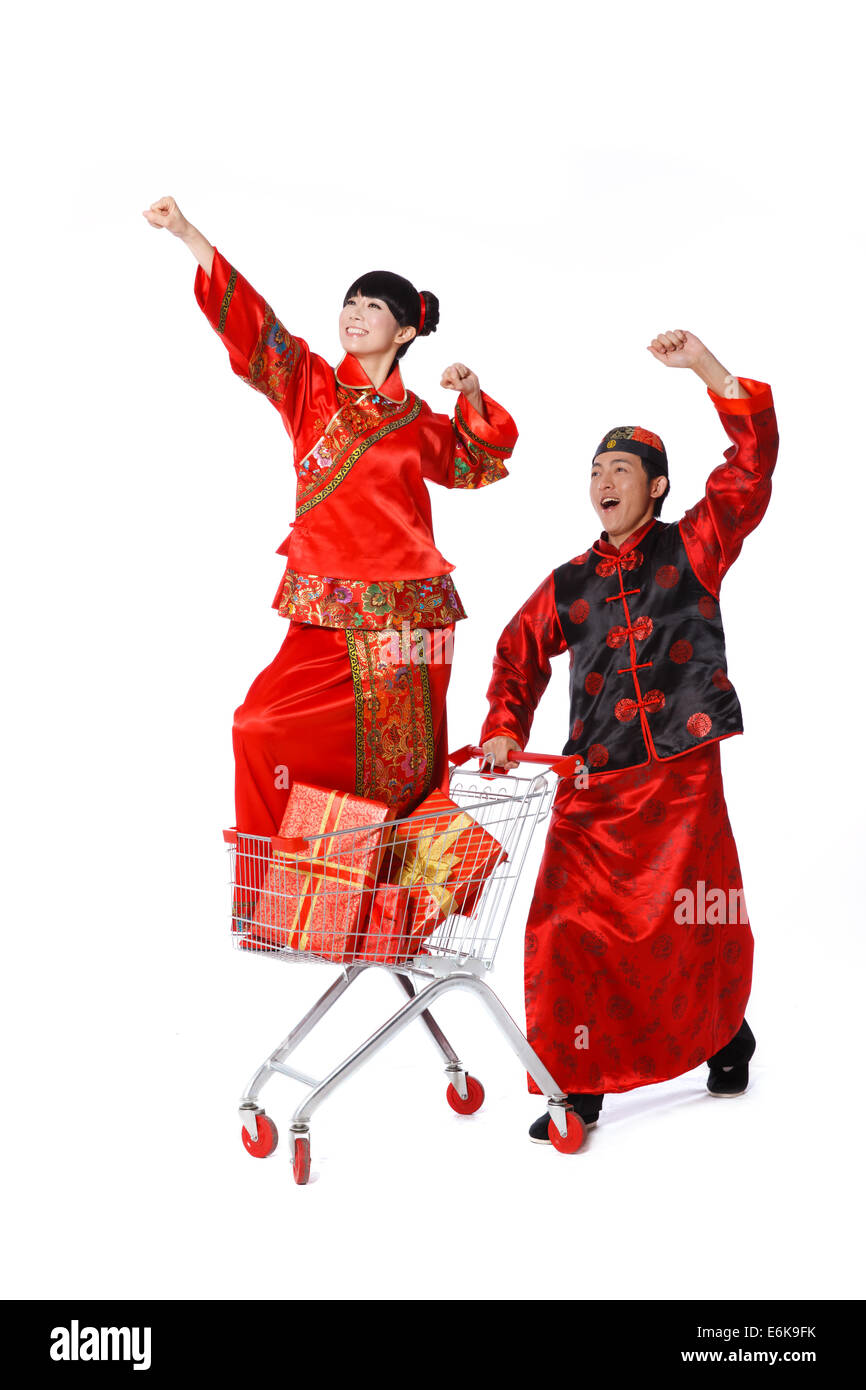 Young couple dressed in traditional clothes shopping with cart Stock ...