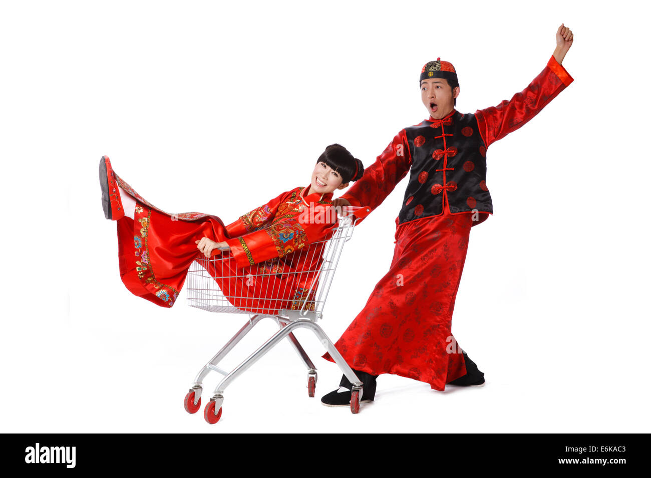 Young couple dressed in traditional clothes shopping with cart Stock ...