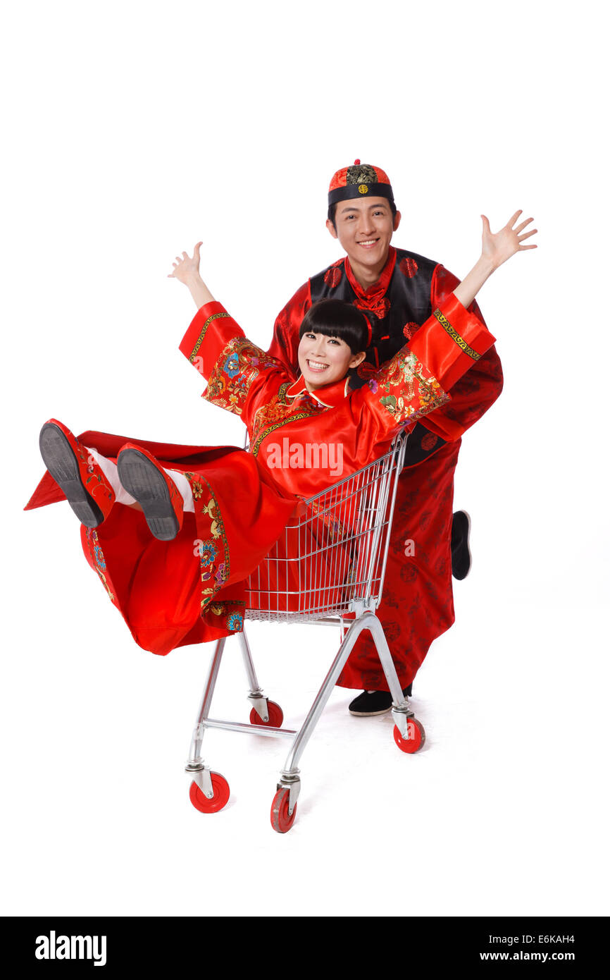Young couple dressed in traditional clothes shopping with cart Stock ...