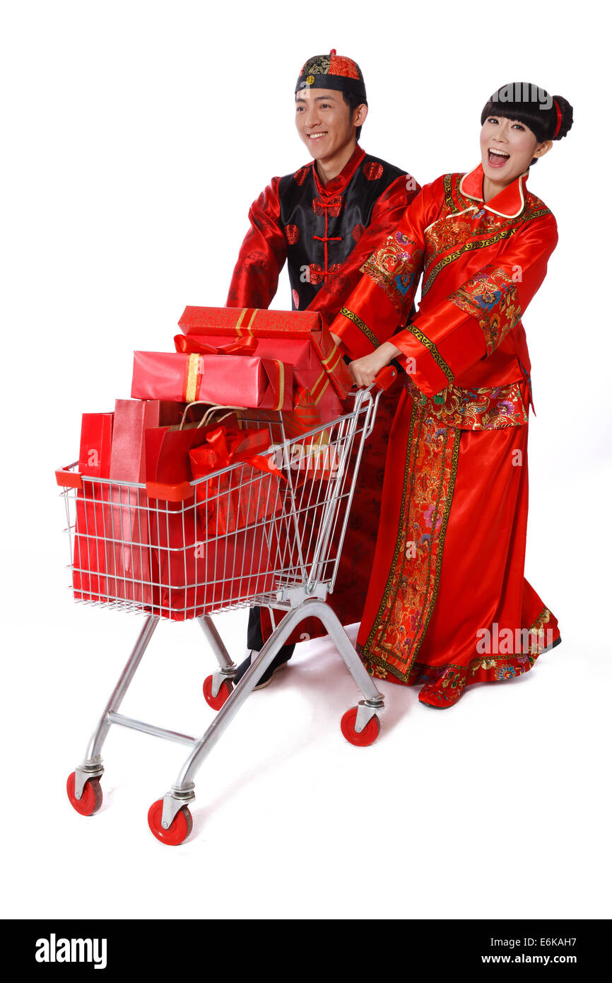 Young couple dressed in traditional clothes shopping with cart Stock ...