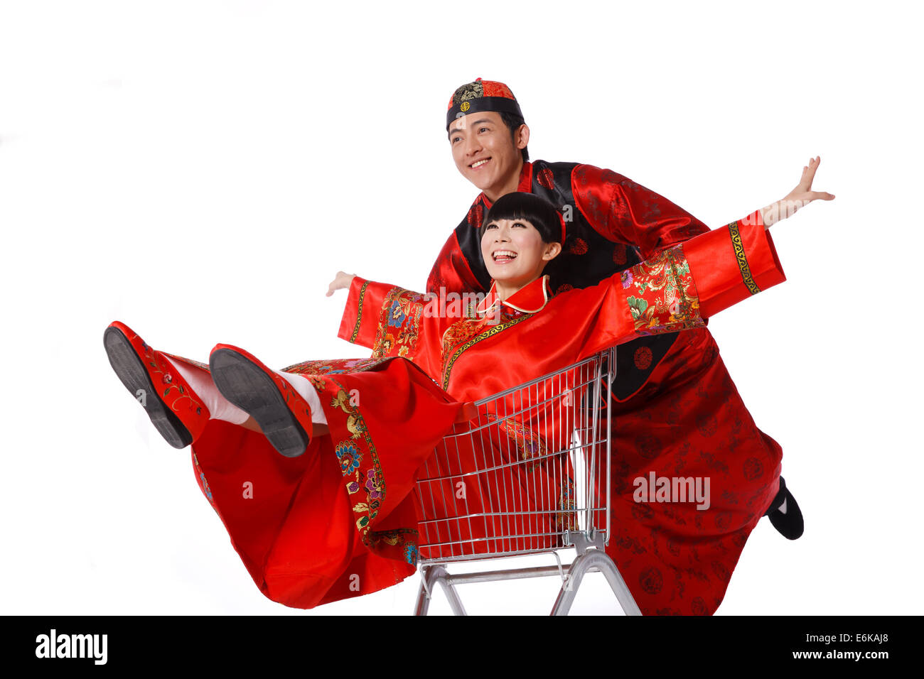 Young couple dressed in traditional clothes shopping with cart Stock ...