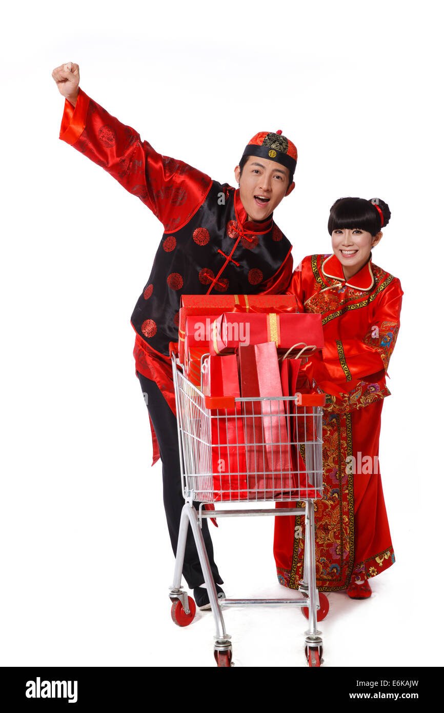 Young couple dressed in traditional clothes shopping with cart Stock ...
