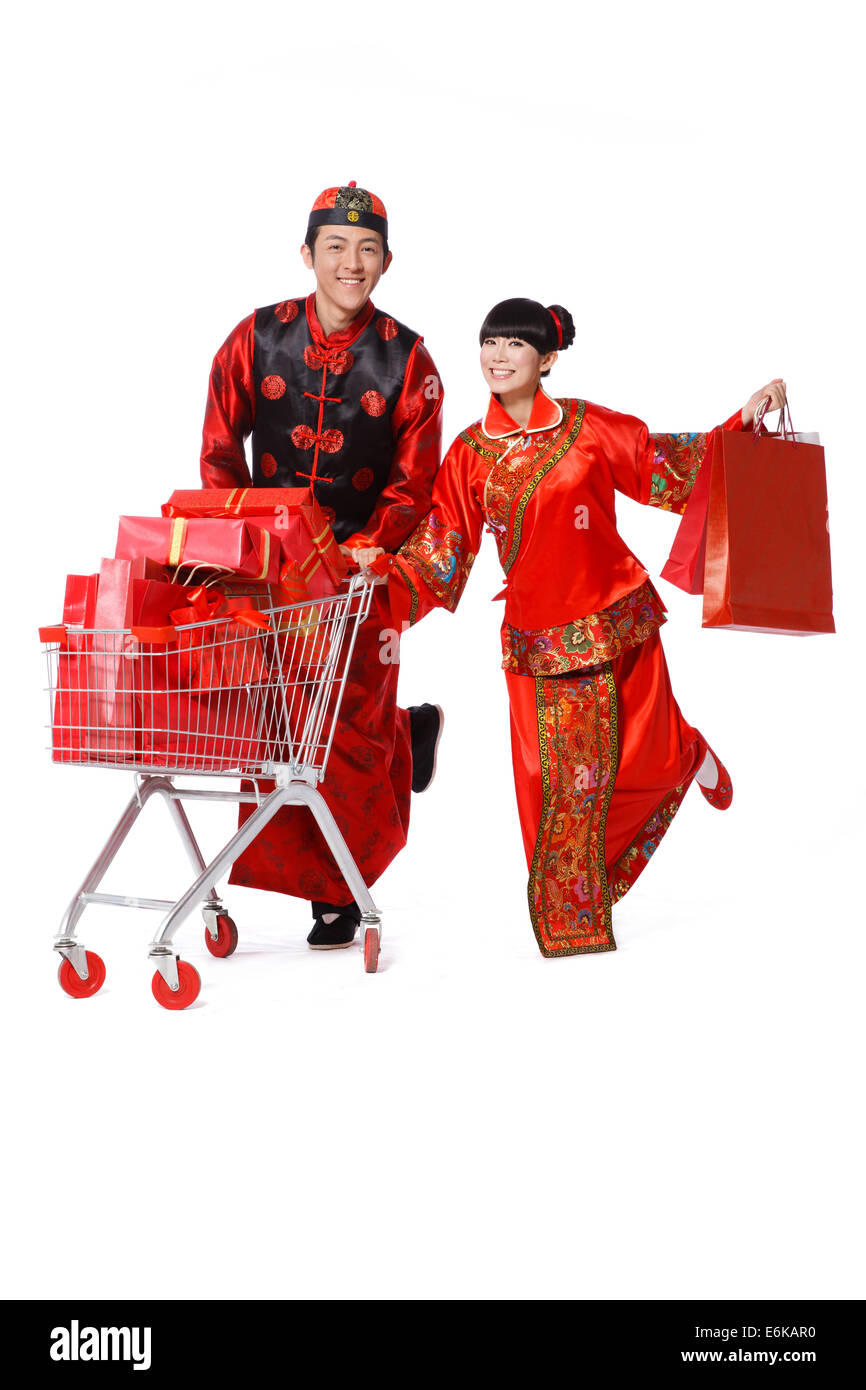 Young couple dressed in traditional clothes shopping with cart Stock ...
