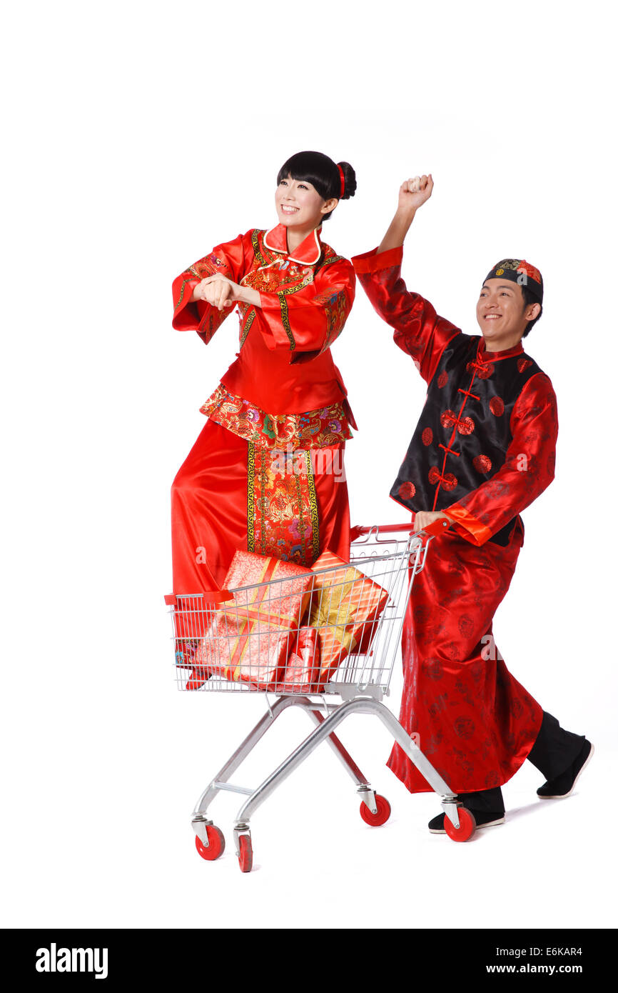 Young couple dressed in traditional clothes shopping with cart Stock ...