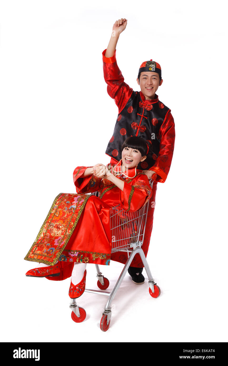 Young couple dressed in traditional clothes shopping with cart Stock ...