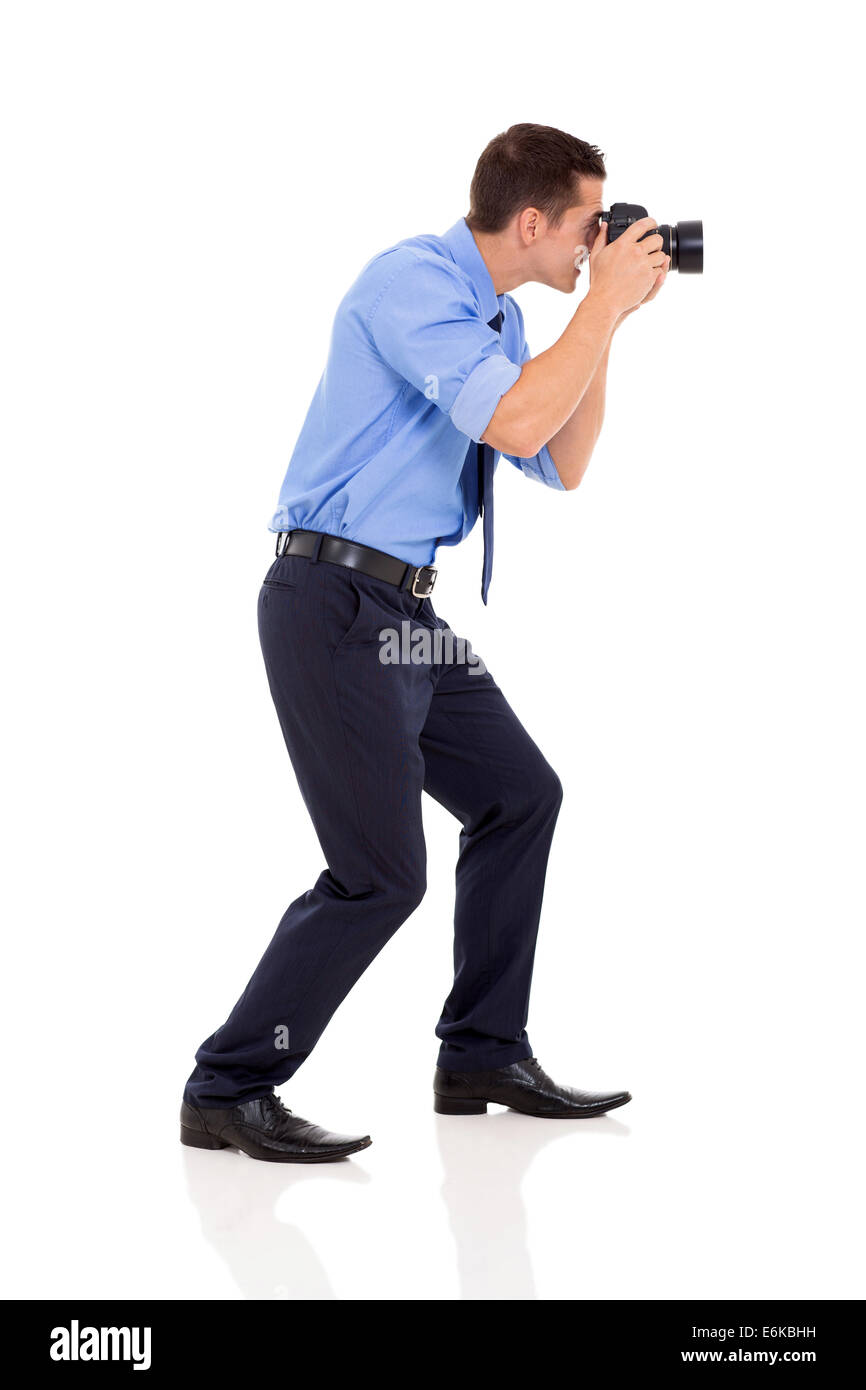 side view of male photographer shooting photos on white background ...