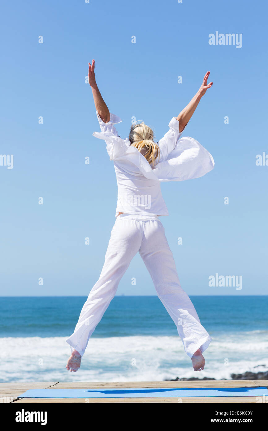 rear view of happy woman jumping on beach Stock Photo - Alamy