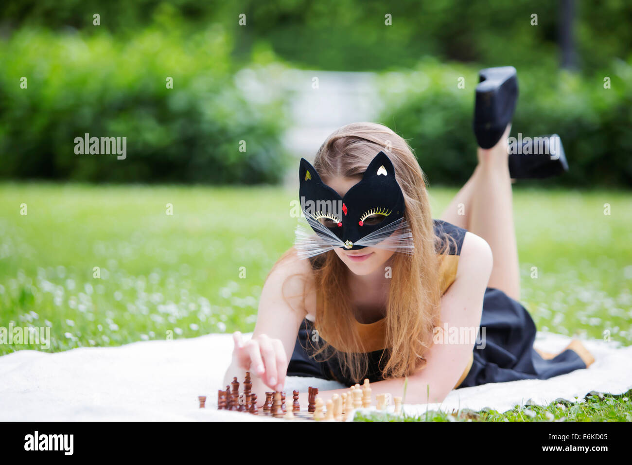 Young woman with mask adjust wooden chess pieces Stock Photo - Alamy