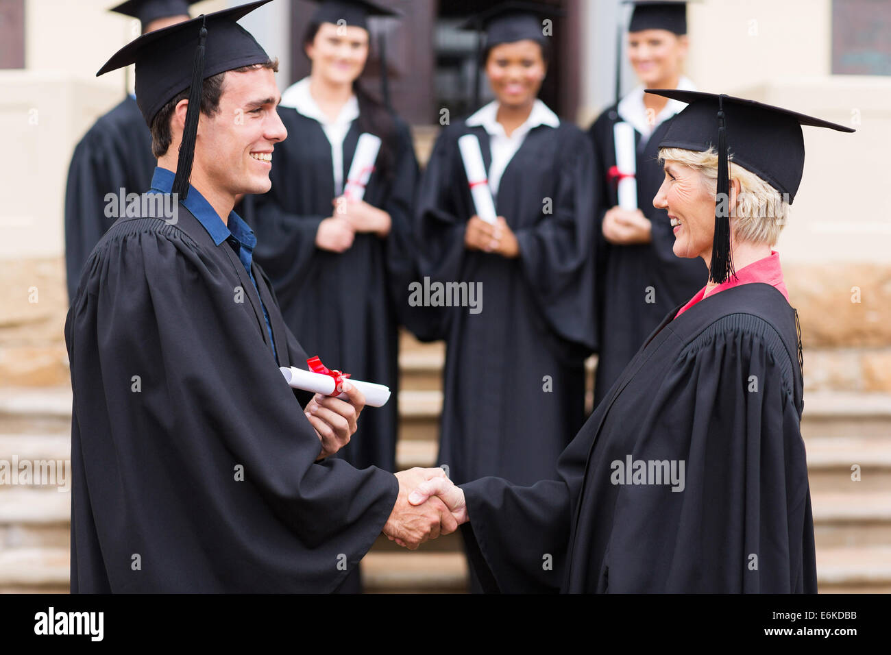 happy young graduate shaking hand with professor Stock Photo - Alamy