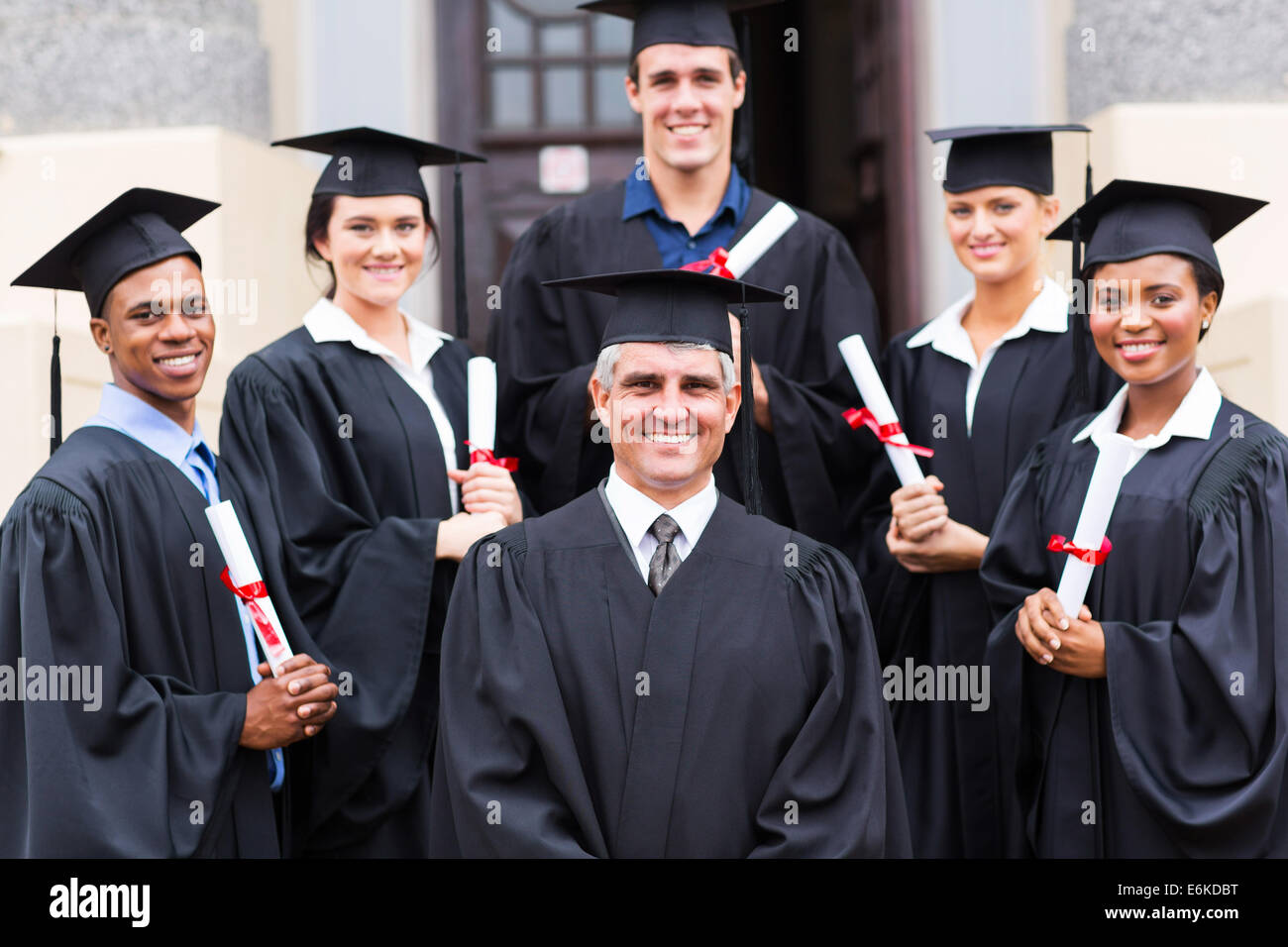 dean standing with group of happy graduates outside university Stock ...