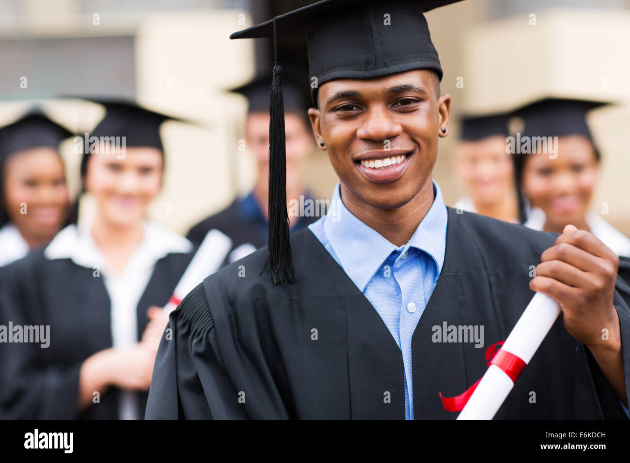 good looking African American male graduate in front of classmates ...