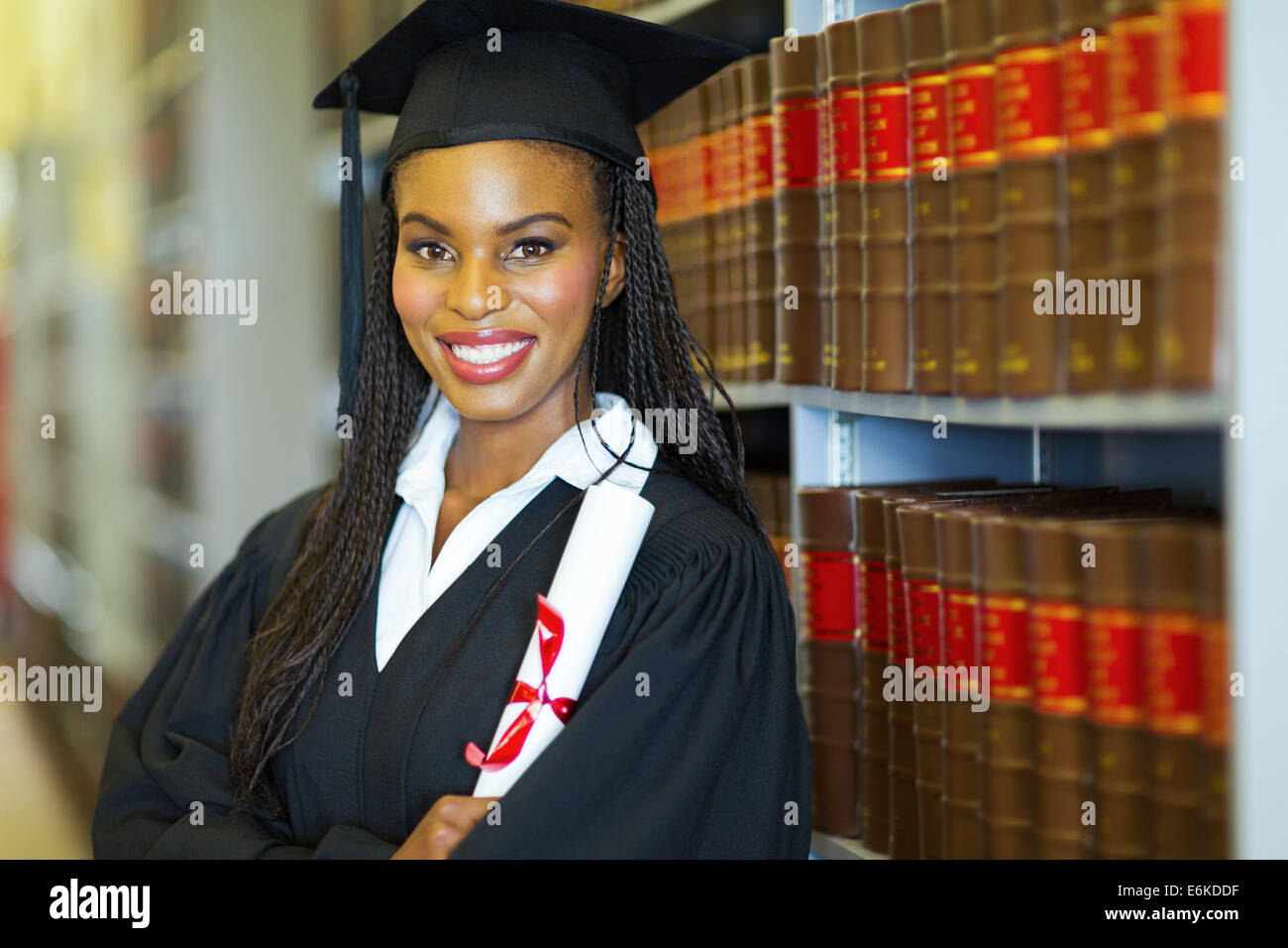 beautiful African female graduate in library on graduation day Stock ...