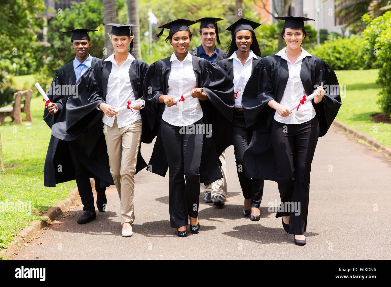 group of cute multiracial graduates walking on college campus Stock ...
