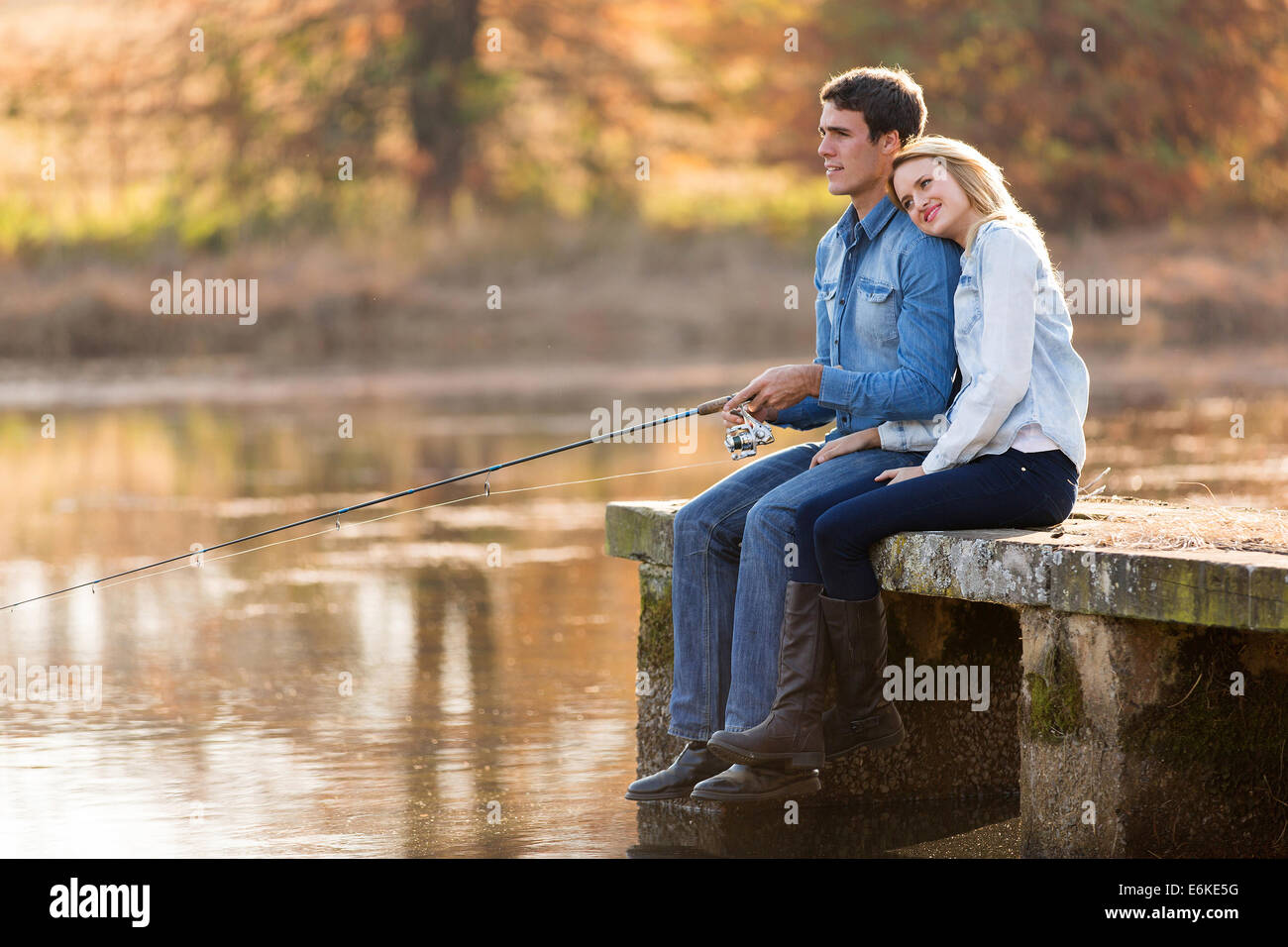 peaceful young couple fishing by the pond in autumn Stock Photo - Alamy