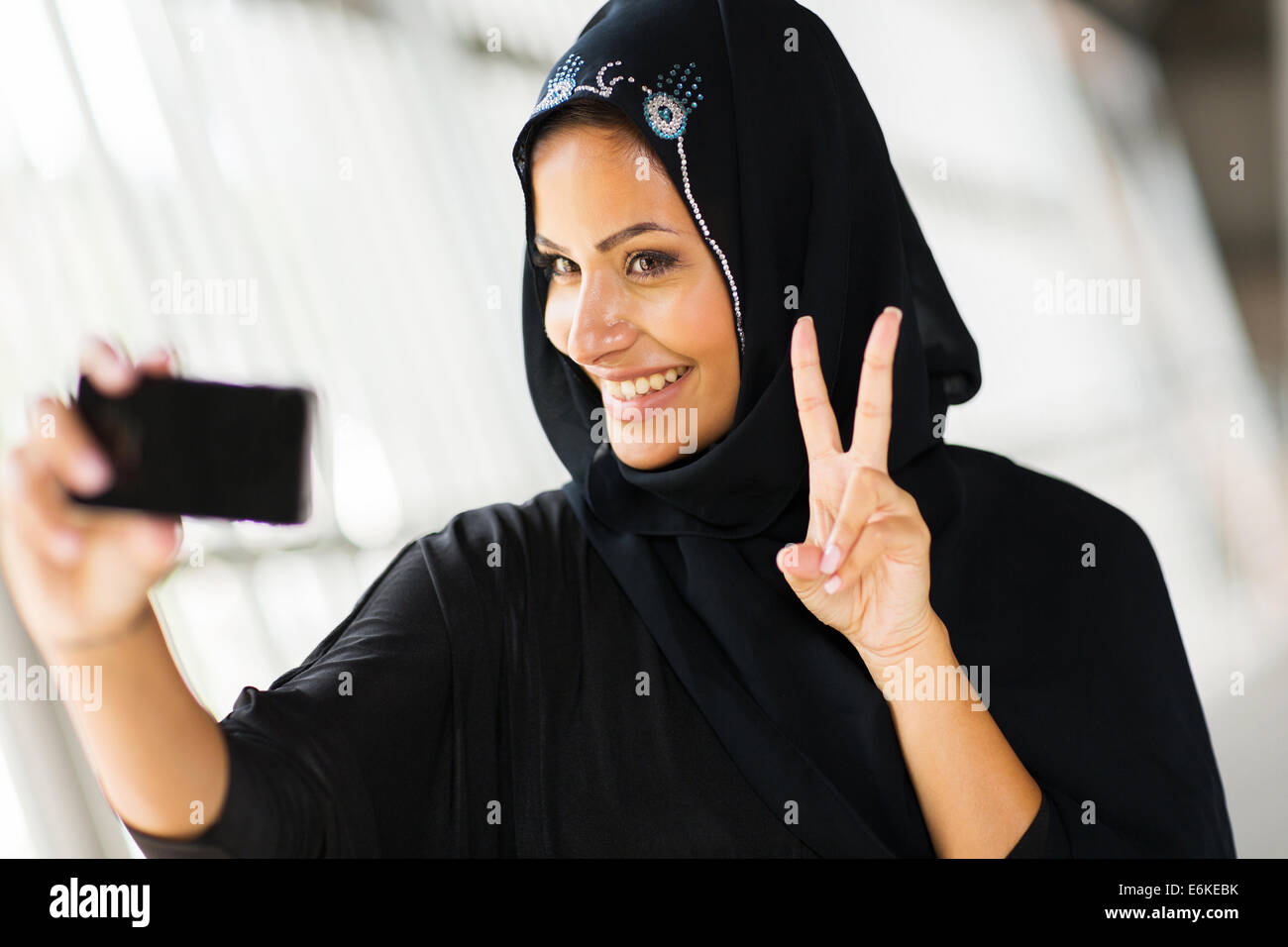 beautiful young Muslim woman taking self portrait with smart phone ...