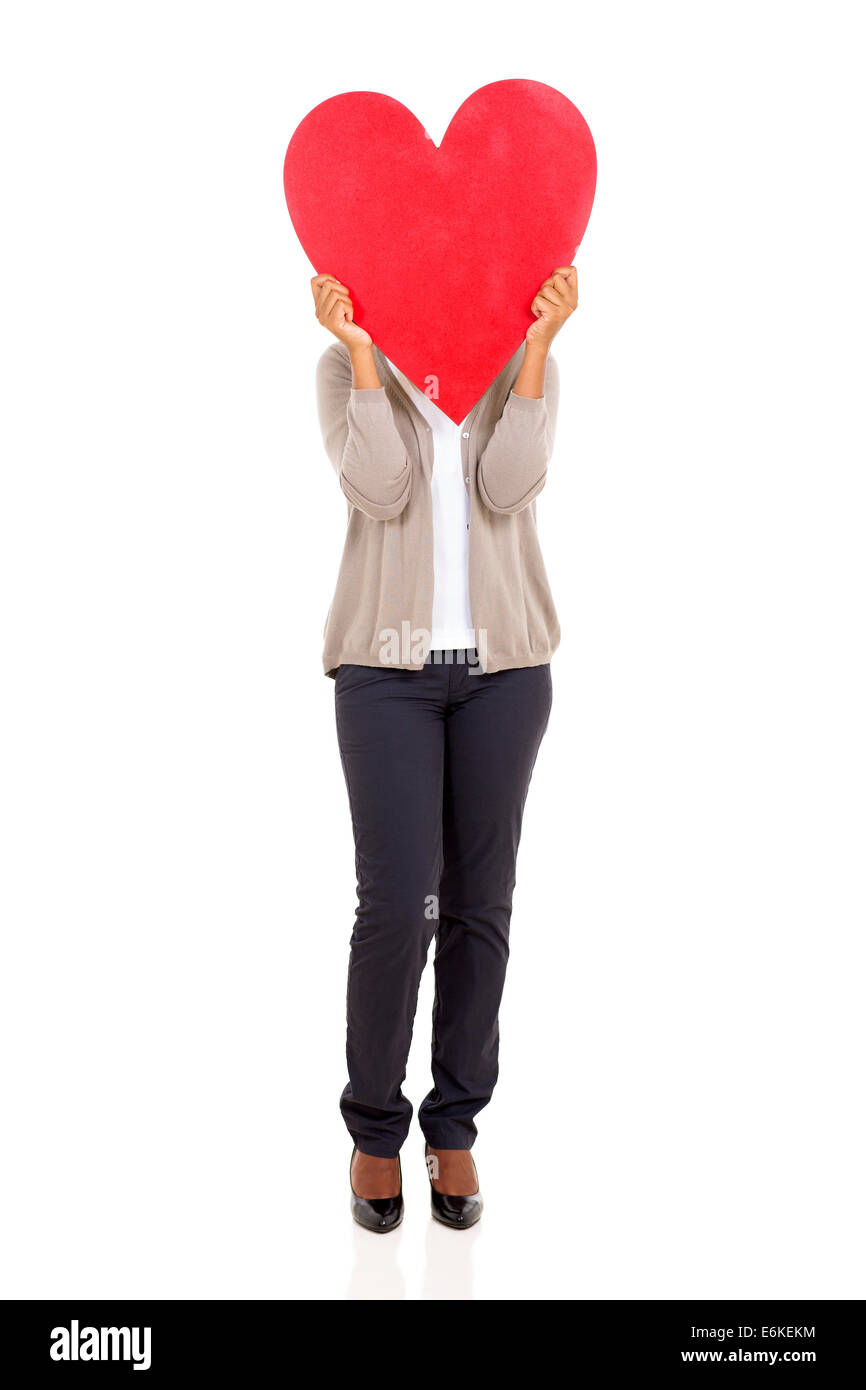 young woman hiding her face behind red heart shape isolated on white ...