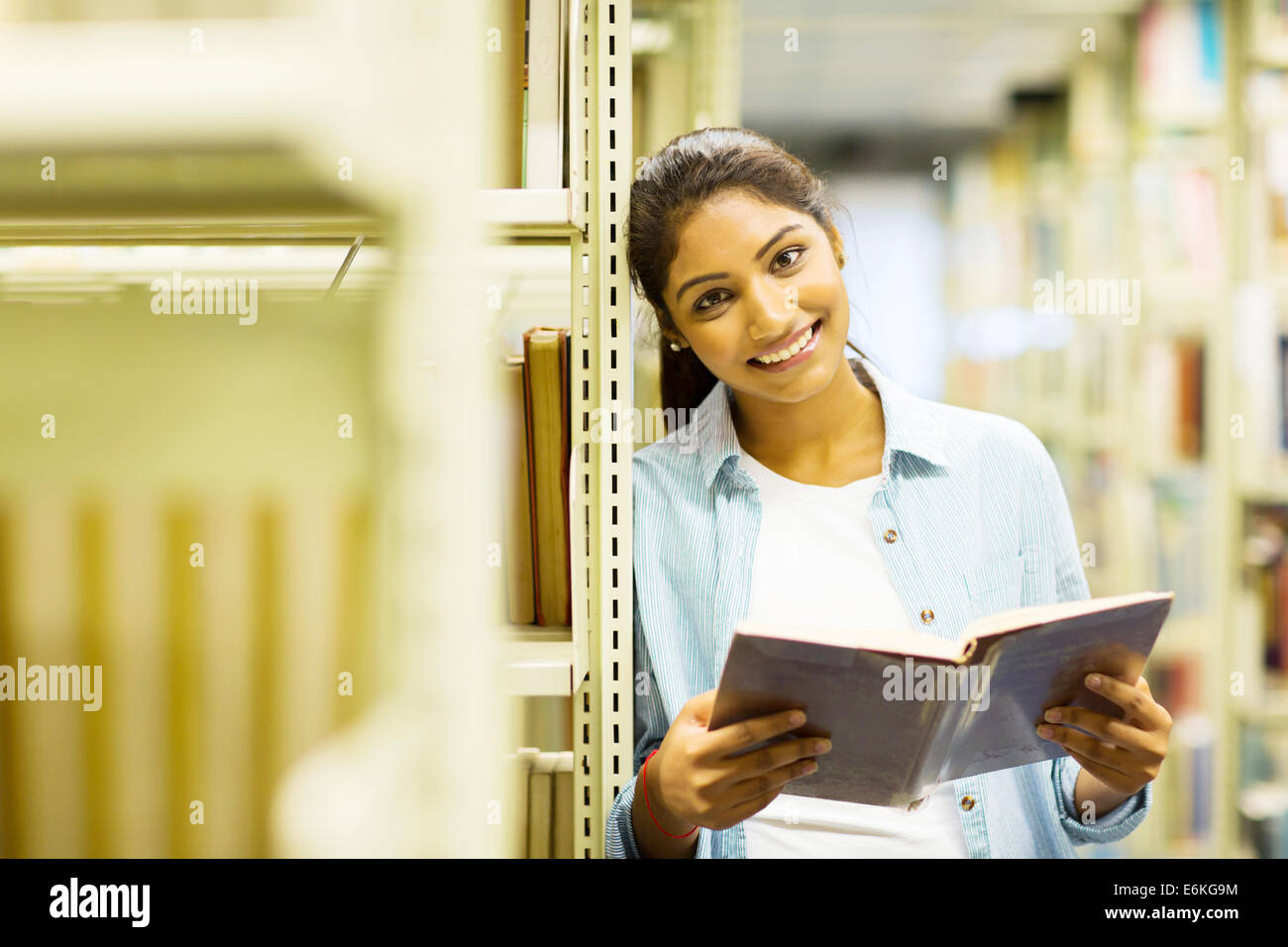 happy female college student reading in library Stock Photo - Alamy