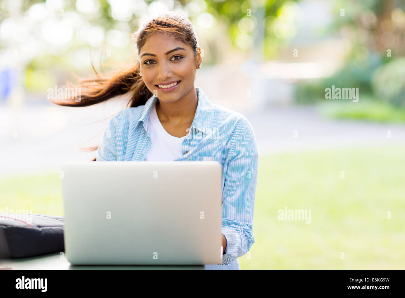 beautiful Indian college student with laptop sitting outdoors Stock ...