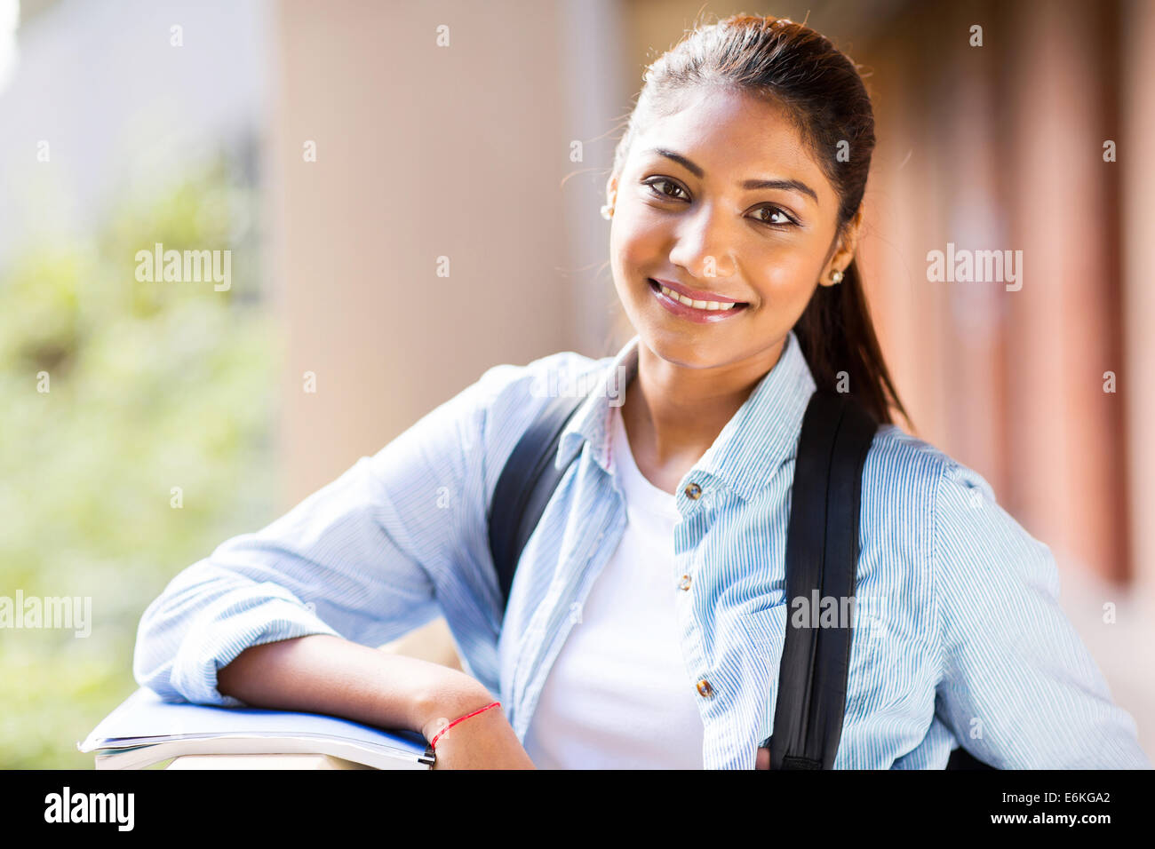 portrait of attractive female university student standing by hallway ...