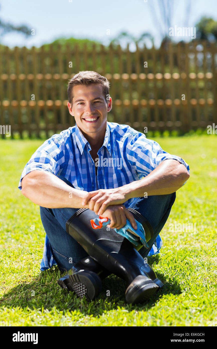 handsome young man sitting on the lawn relaxing after garden work Stock ...