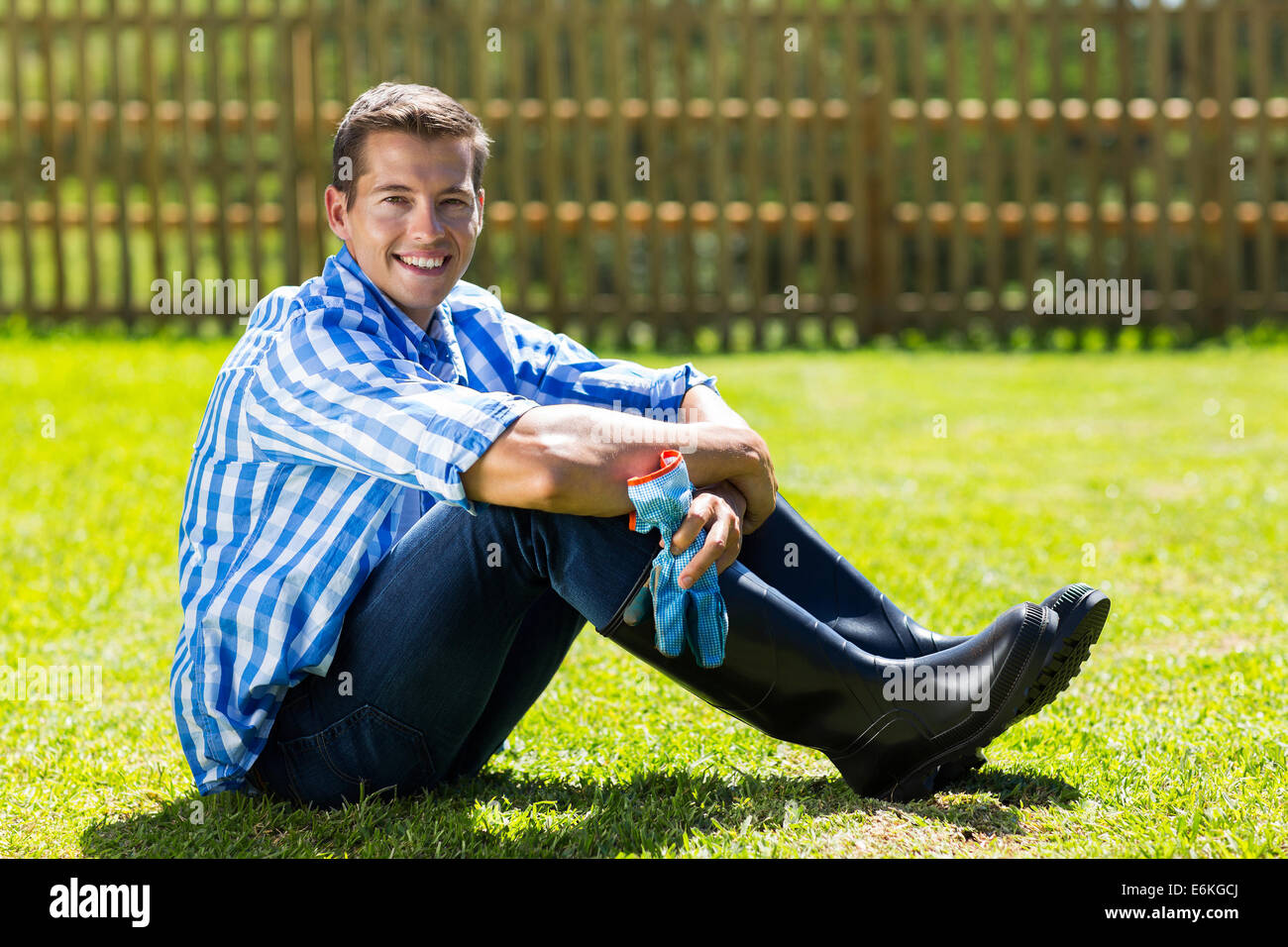good looking gardener sitting on lawn Stock Photo - Alamy