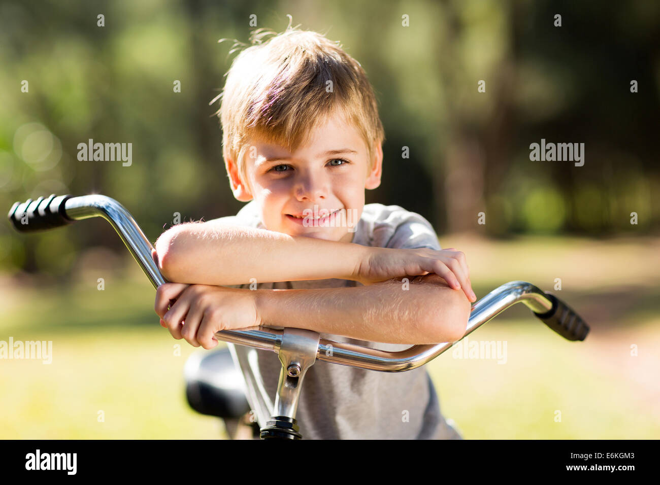 smiling cute little boy resting on a bicycle in the forest Stock Photo ...