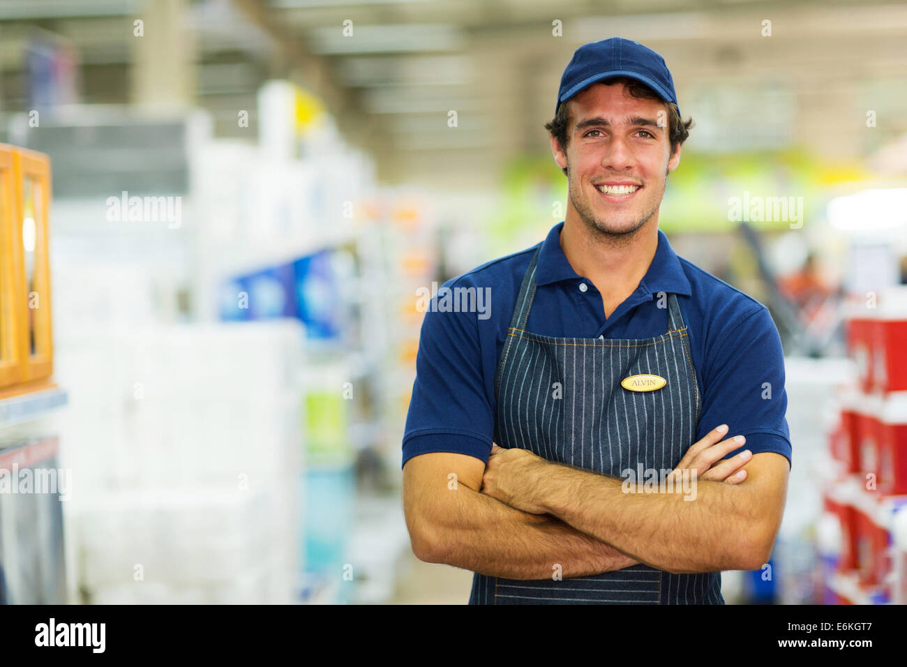 happy young salesman standing in hardware store Stock Photo - Alamy