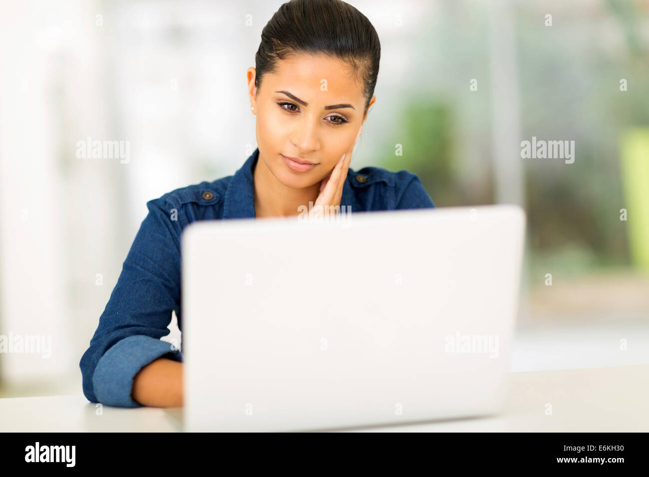 thoughtful young woman looking at the laptop screen Stock Photo - Alamy