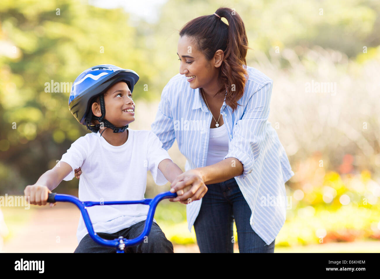 loving mother help her cute son ride a bicycle Stock Photo - Alamy