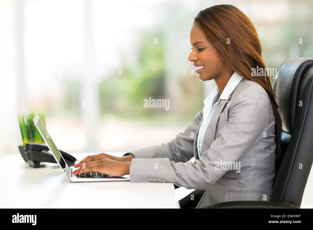 attractive African office worker using laptop computer Stock Photo - Alamy
